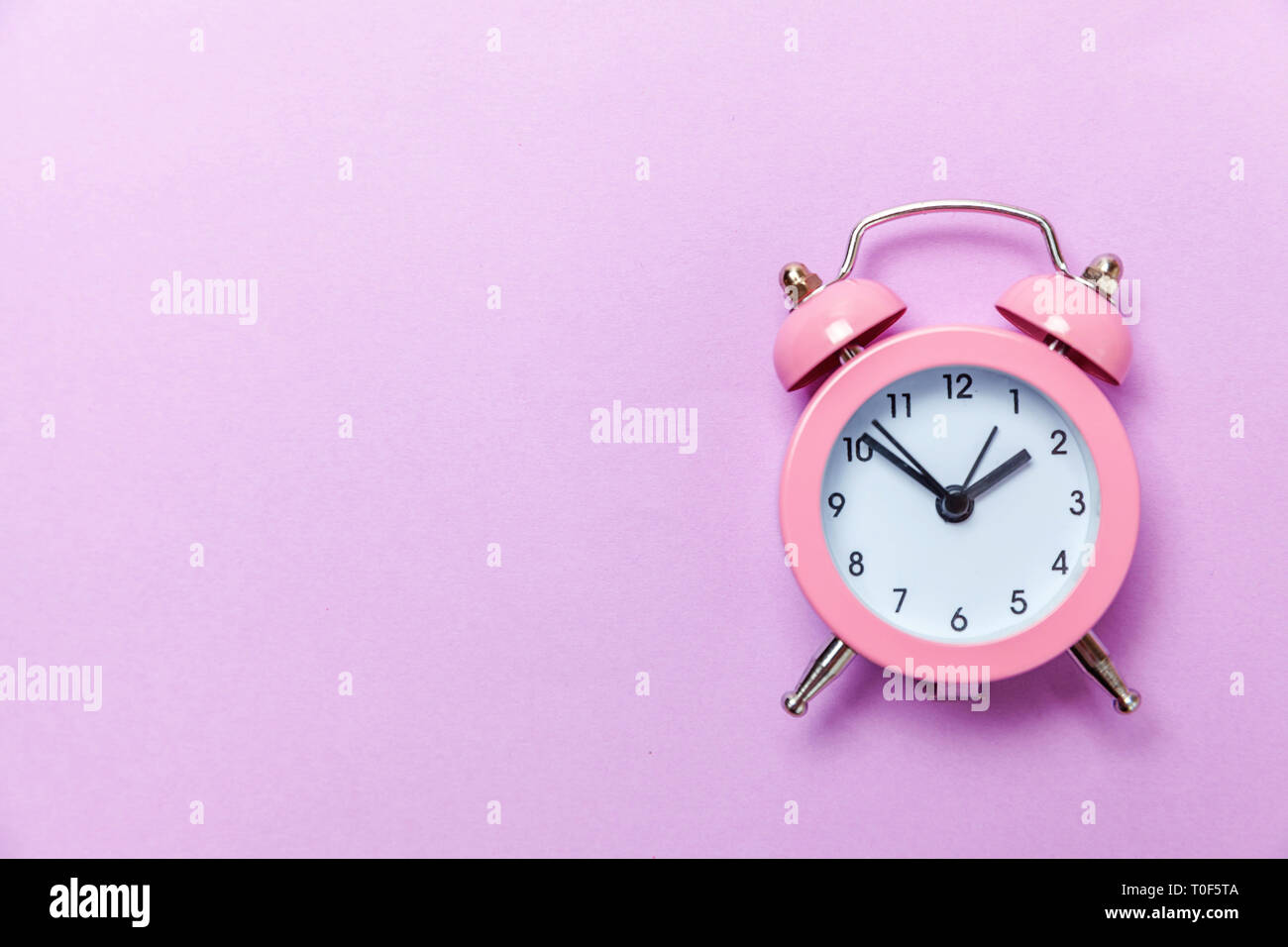 Ringing twin bell vintage classic alarm clock Isolated on purple violet ...