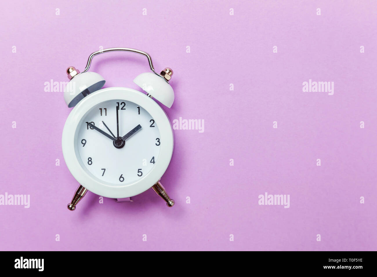 Ringing twin bell vintage classic alarm clock Isolated on purple violet ...
