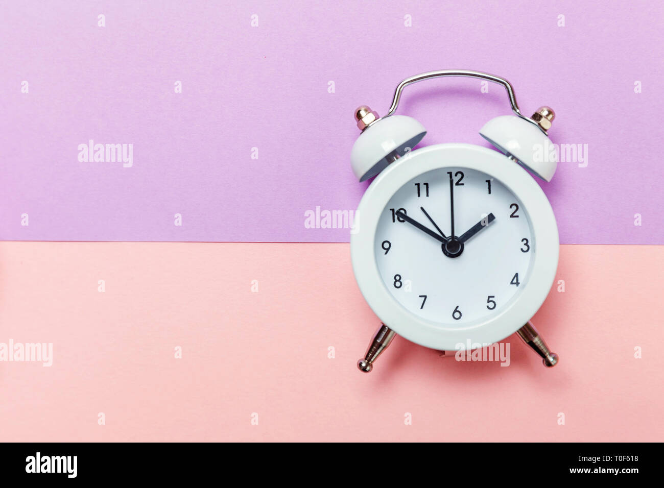 Ringing twin bell vintage classic alarm clock Isolated on purple pink ...