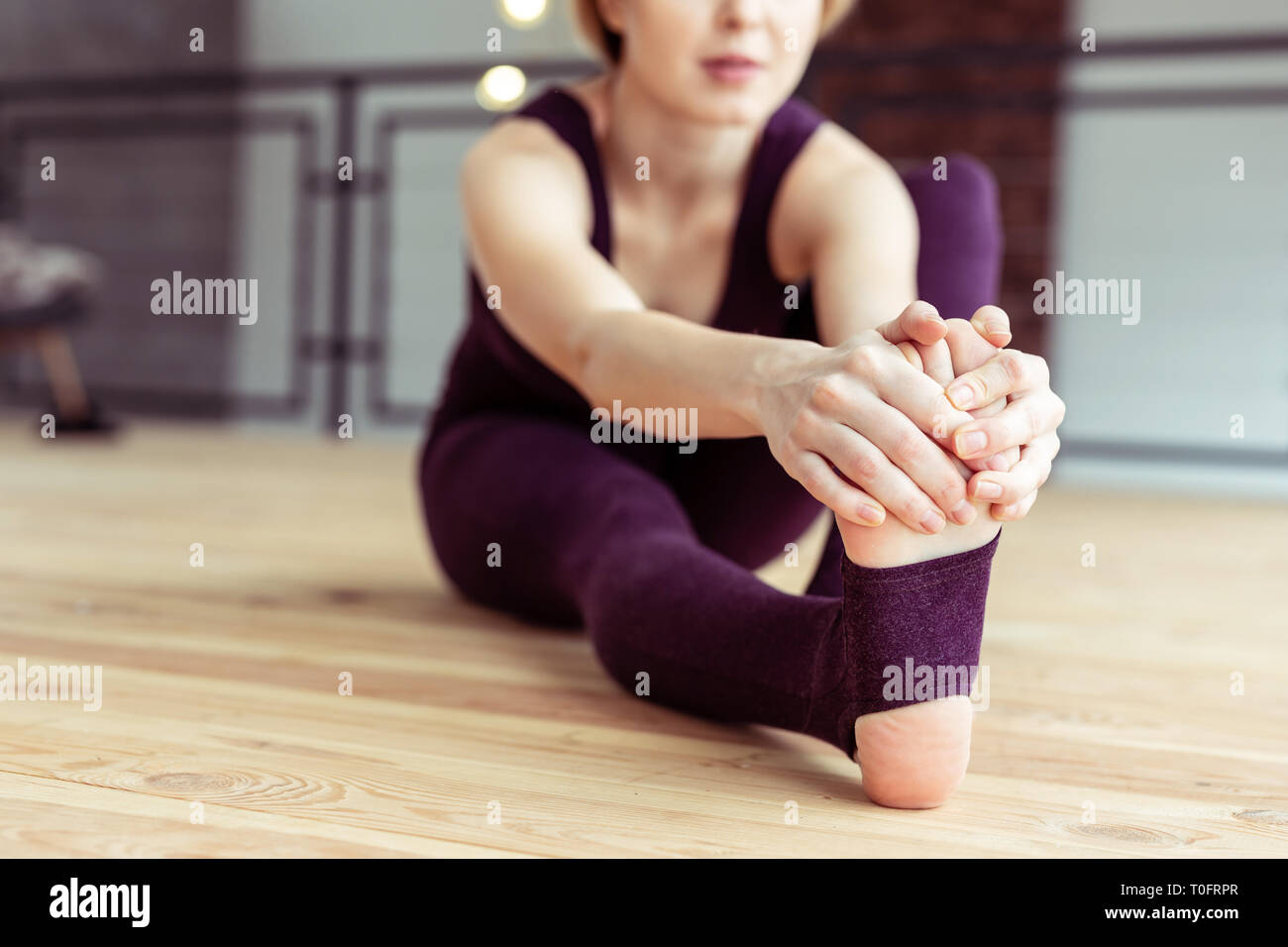 Concentrated skinny girl being busy with stretching session Stock Photo ...