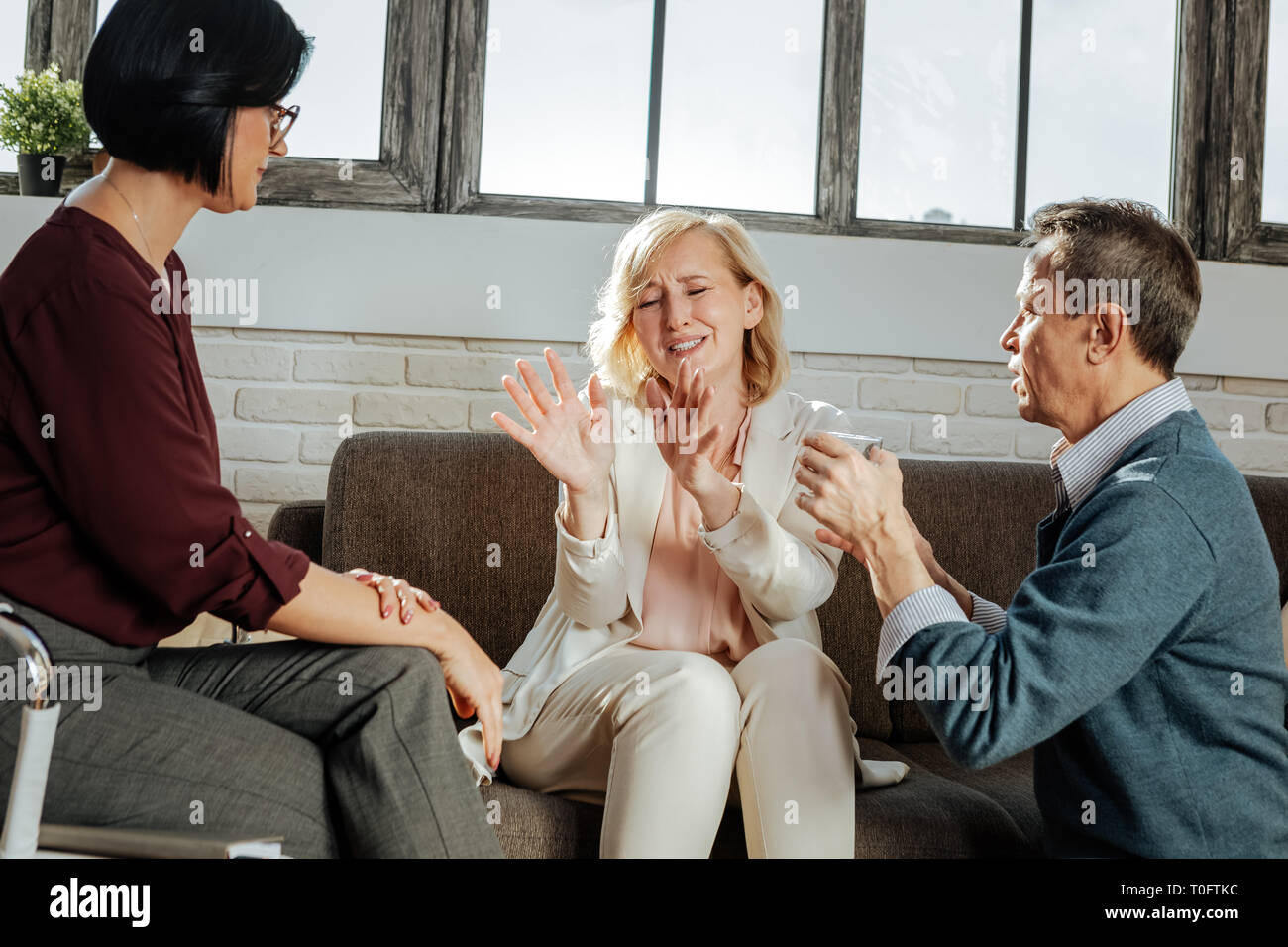 Upset and unhappy good-looking woman actively gesturing and explaining ...