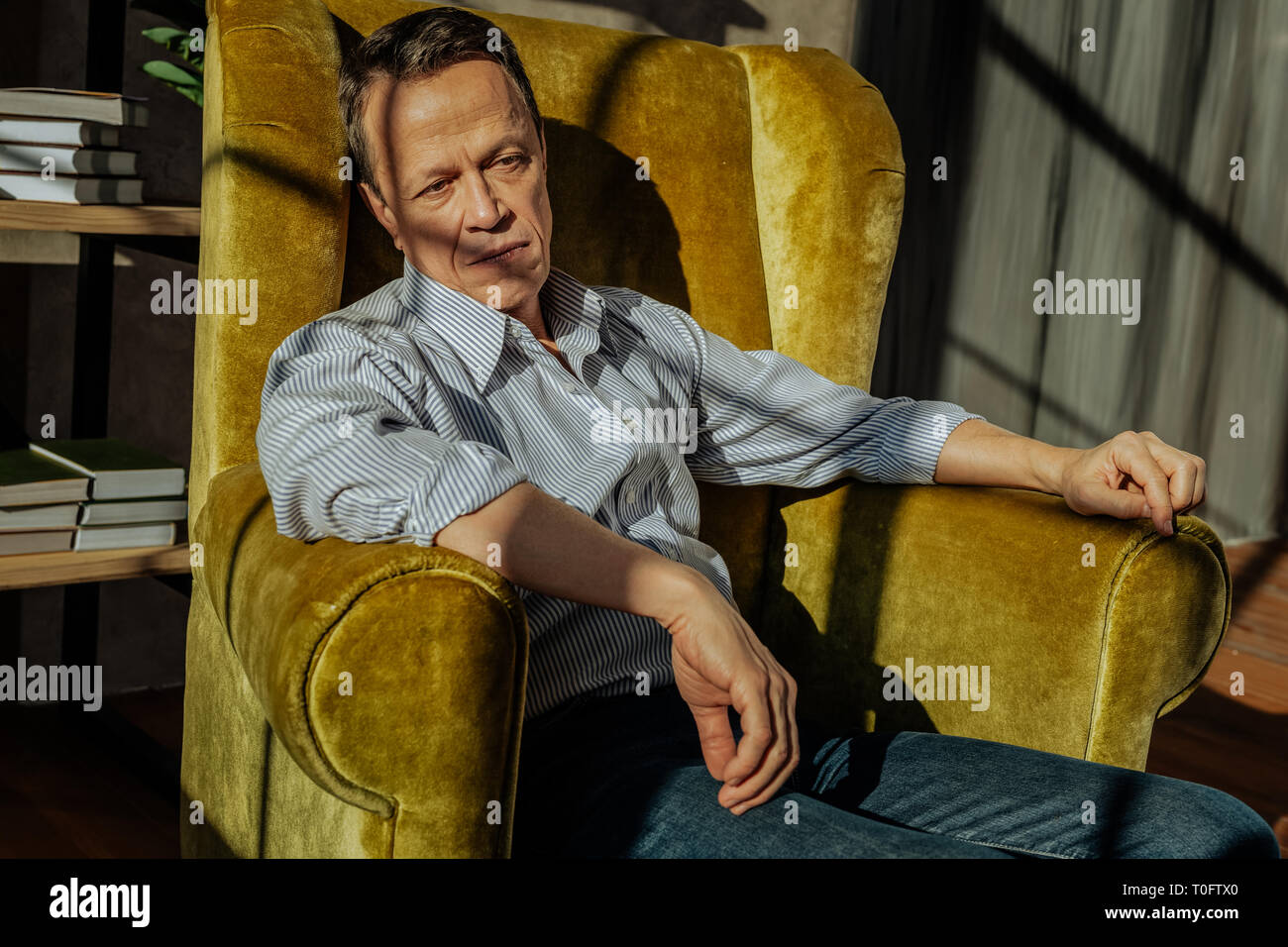 Good-looking short-haired man resting in a spacious armchair Stock ...