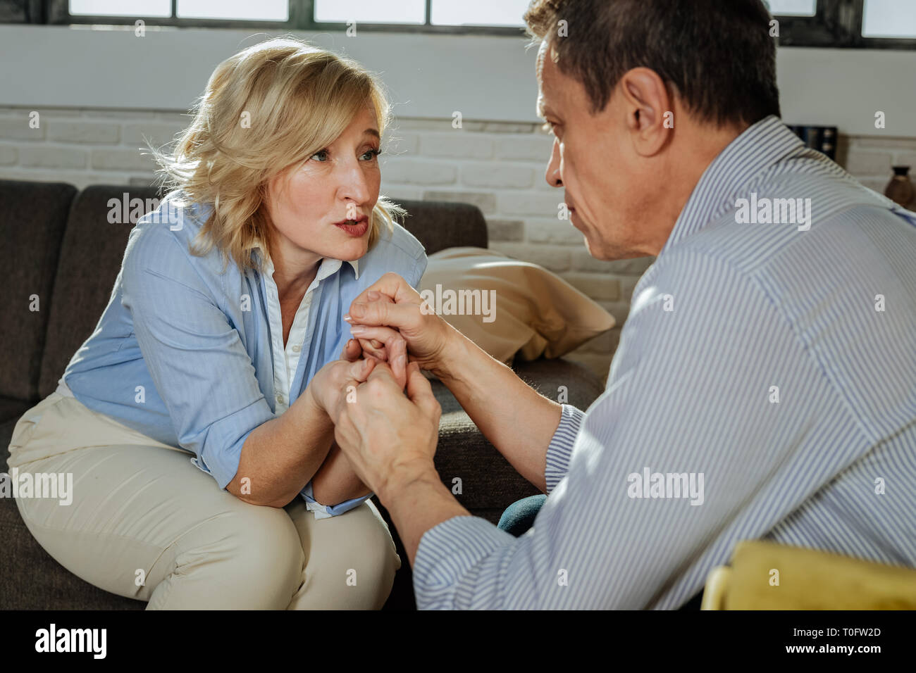 Serious gesture. Desperate old couple having problems and discussing ...