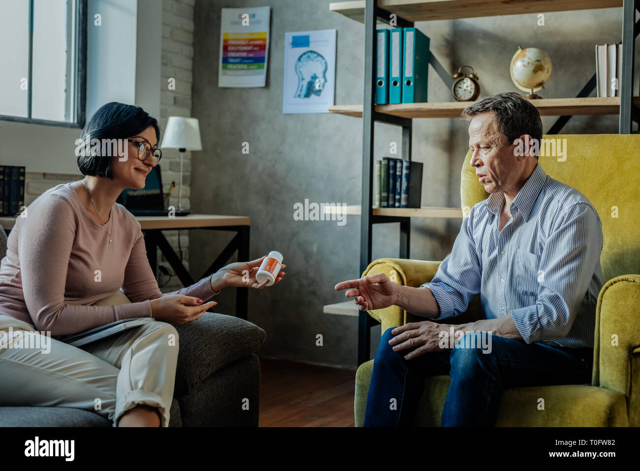 Misunderstood man in a light shirt confusedly pointing on container ...