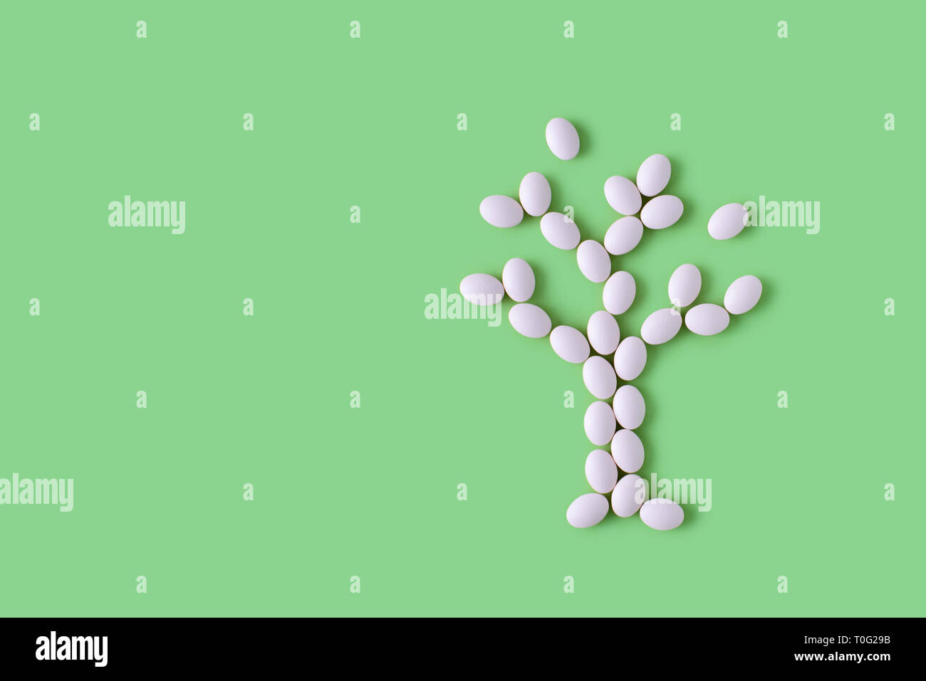 Pills in shape of tree on green background. Flat lay, top view. Free ...