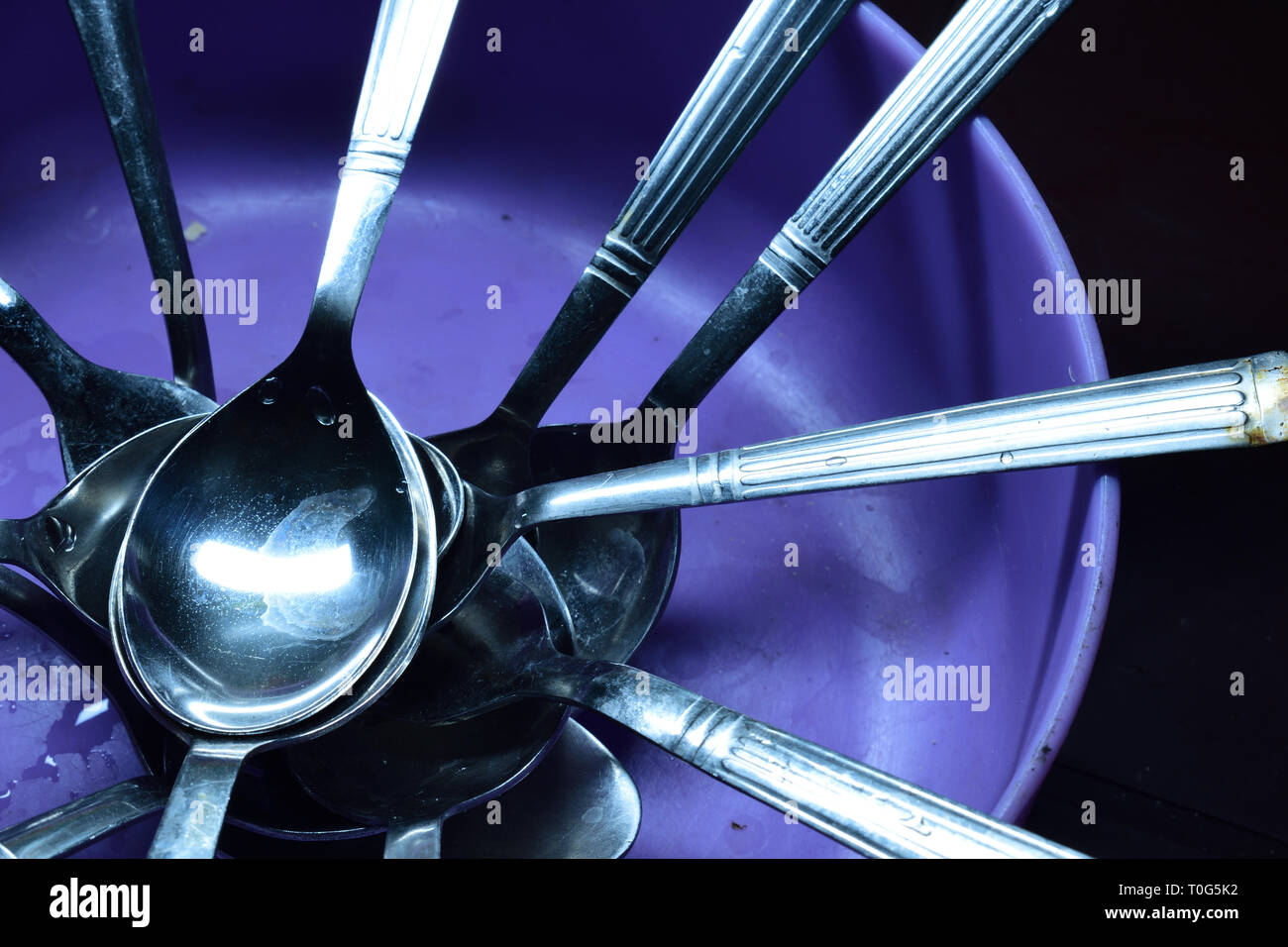 A stack of kitchen spoon in beautiful violet background Stock Photo - Alamy