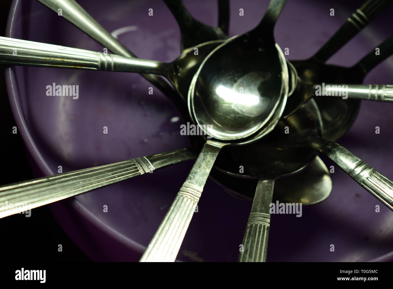 A stack of kitchen spoon in beautiful violet background Stock Photo - Alamy