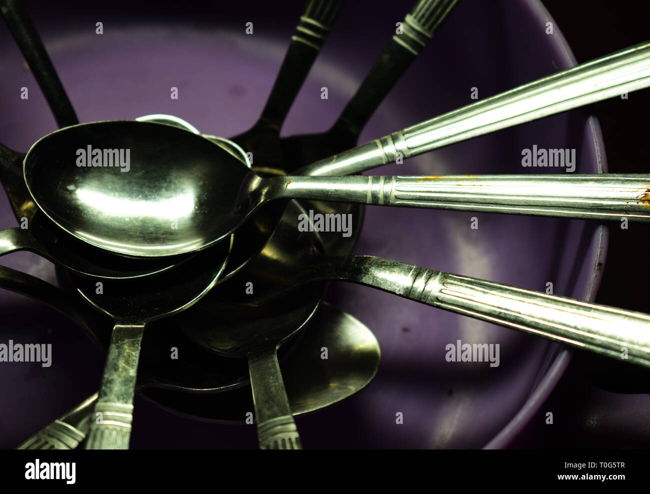 A stack of kitchen spoon in beautiful violet background Stock Photo - Alamy
