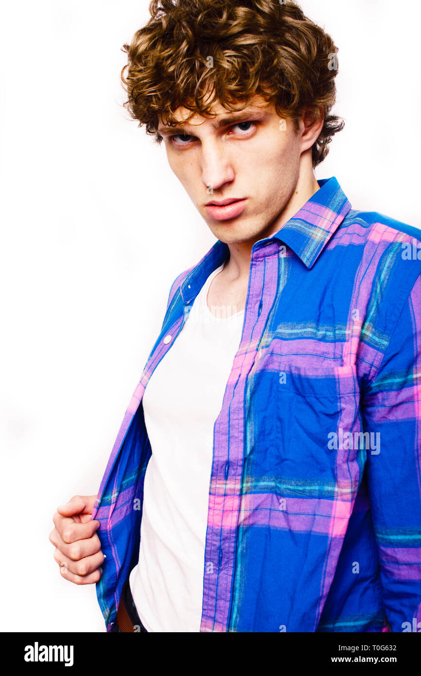 Portrait of a smart serious young man standing against white background ...