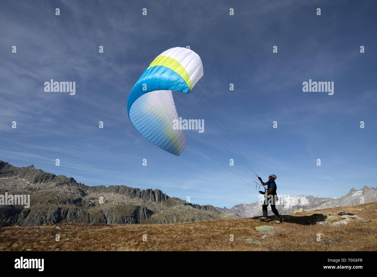 Young paraglider pilot exercises with his paraglider pulling up in the ...