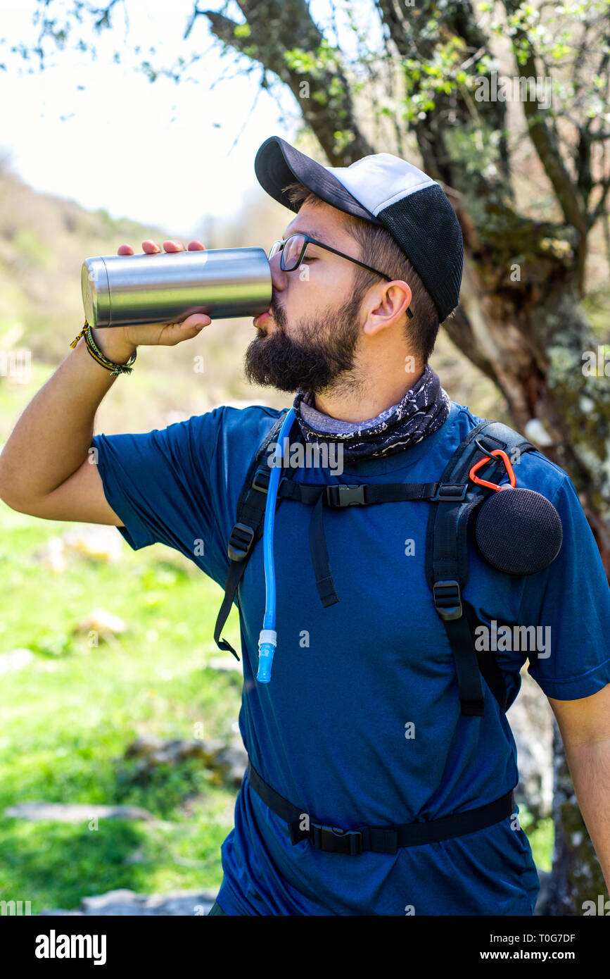 Man drinking from a insulated bottle outdoors Stock Photo - Alamy