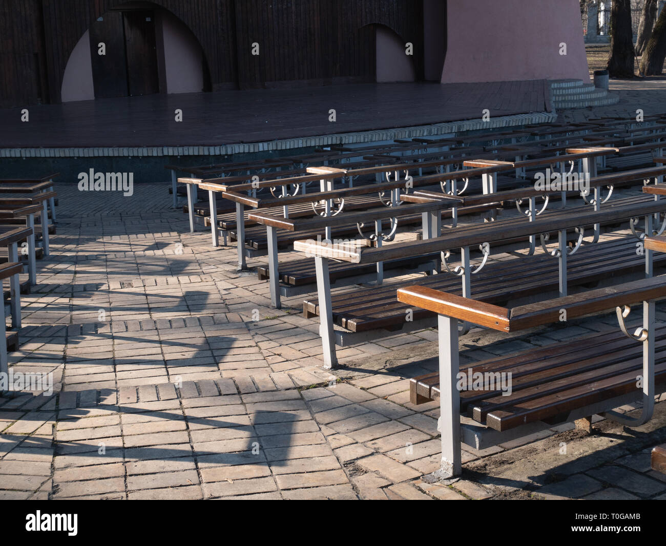 empty rows of wooden benches at open air theater amphitheater, place ...