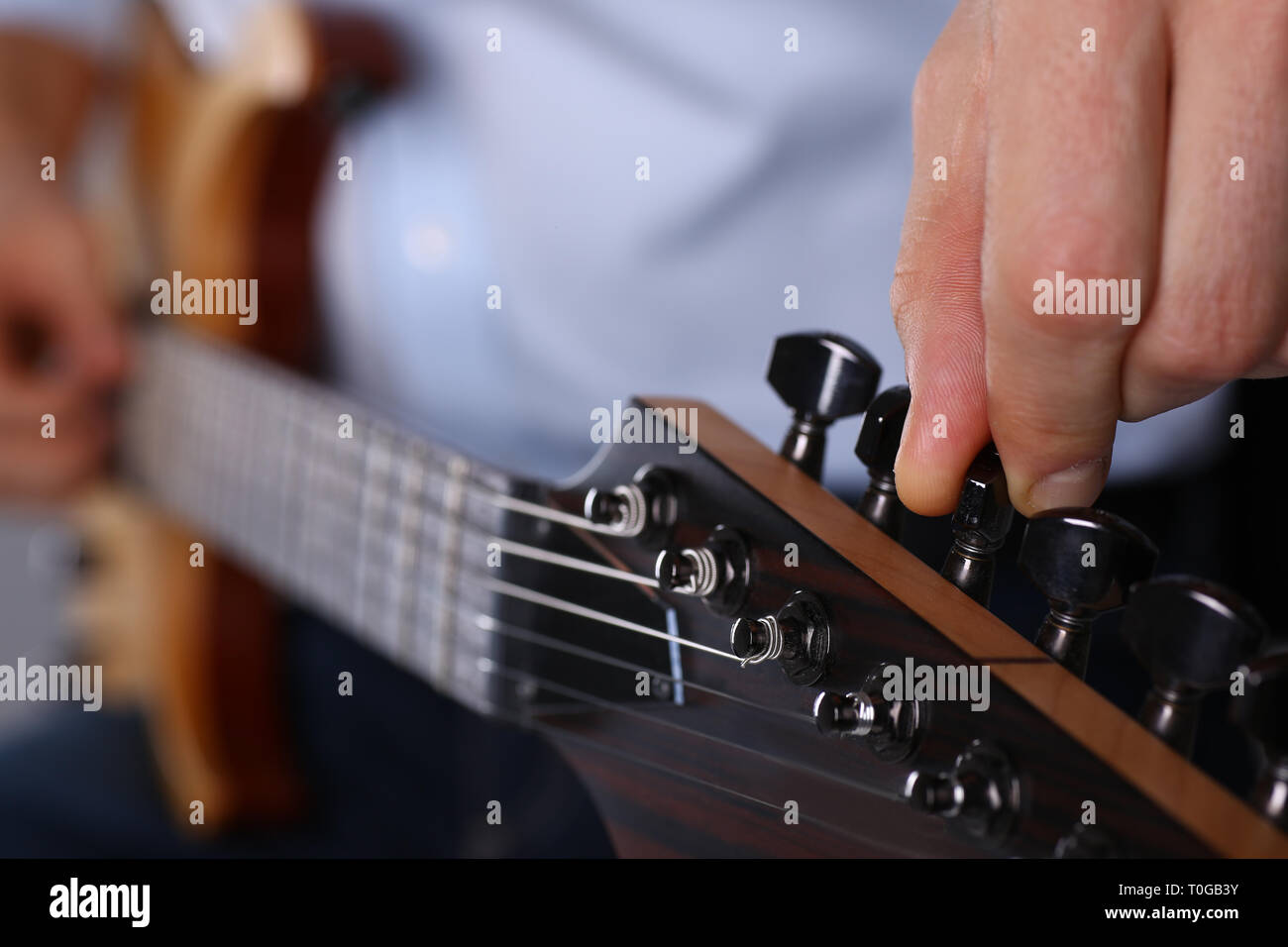 Male arms playing classic shape electric guitar Stock Photo - Alamy