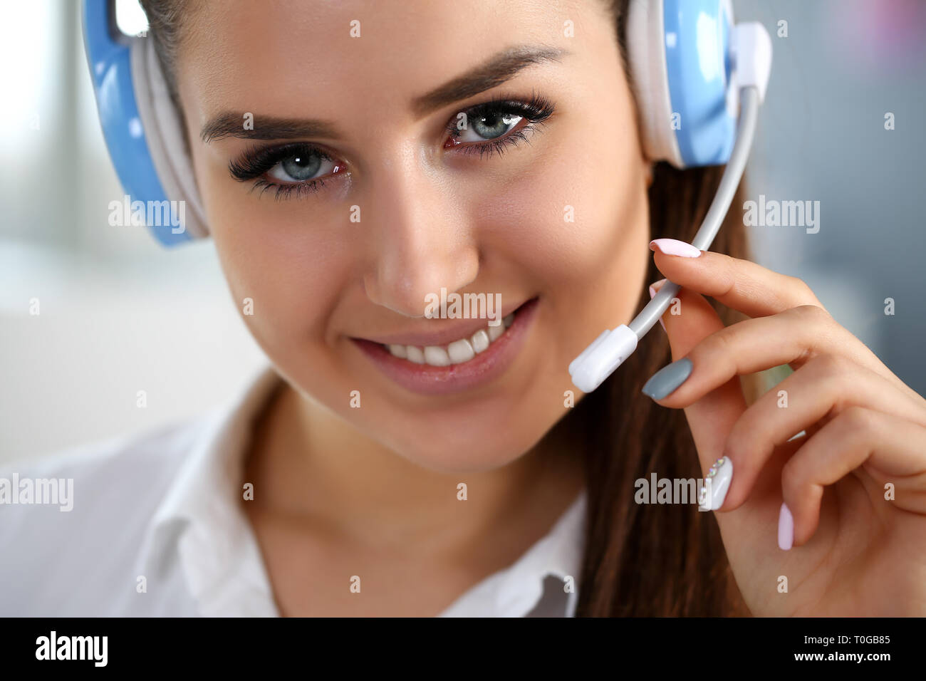 Beautiful brunette smiling call centre clerk at work Stock Photo - Alamy