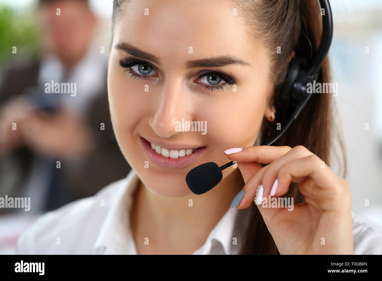 Beautiful brunette smiling call centre clerk at work Stock Photo - Alamy