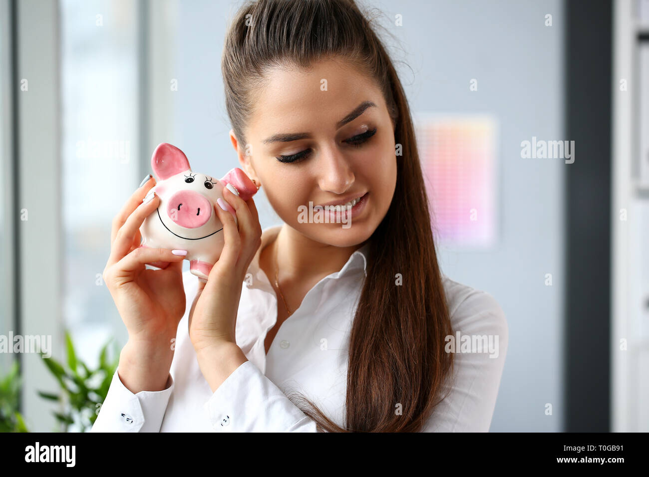 Happy beautiful woman shake in arms funny piggybank Stock Photo - Alamy