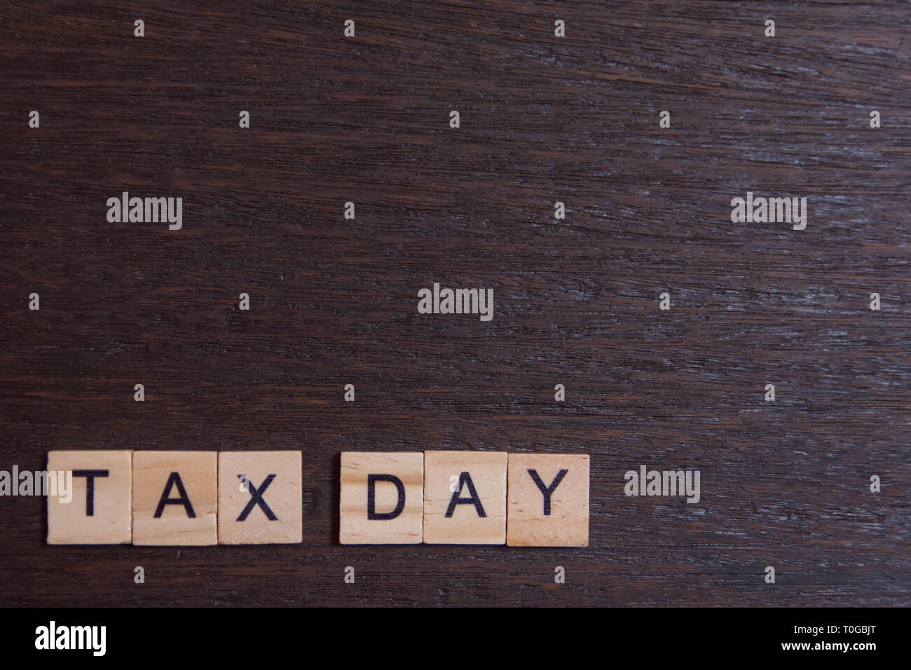 Tax day with wooden alphabet blocks on dark plank wooden background ...