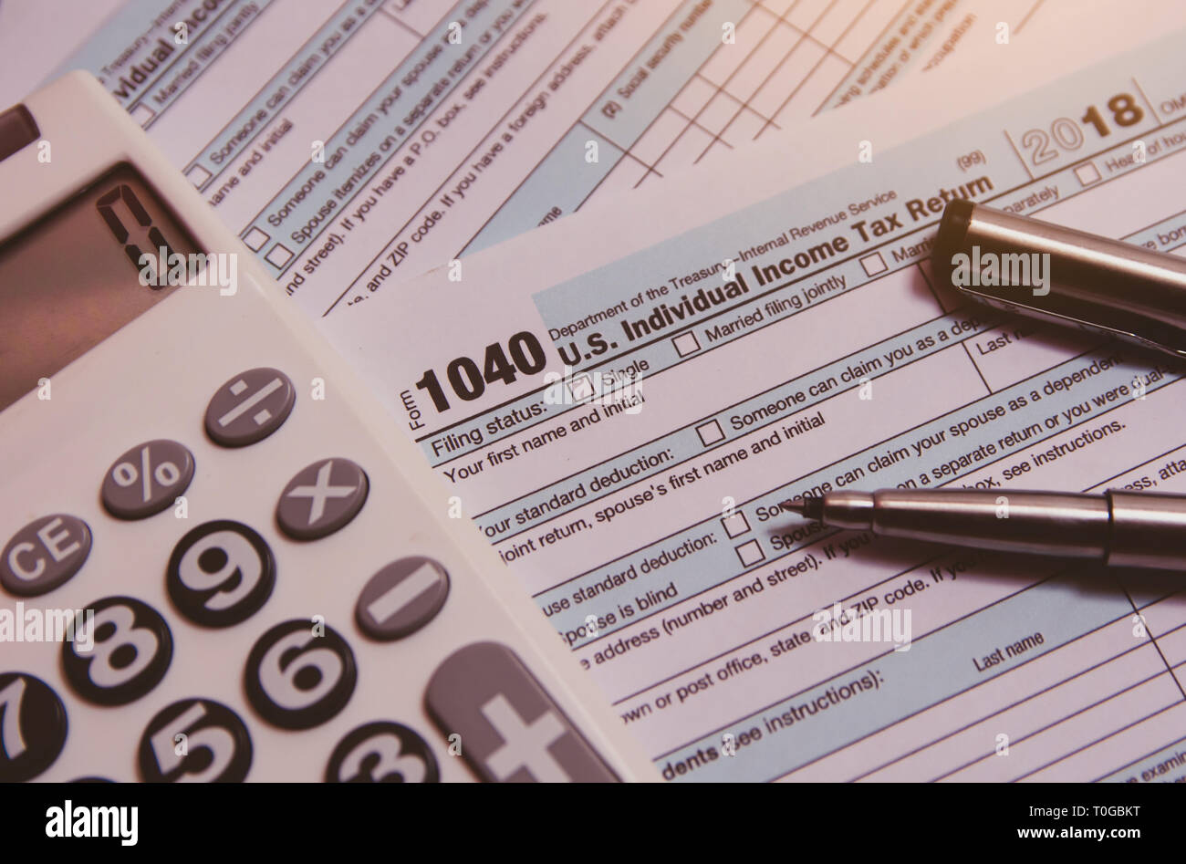 Tax season. calculator, pen on 1040 tax form background Stock Photo - Alamy