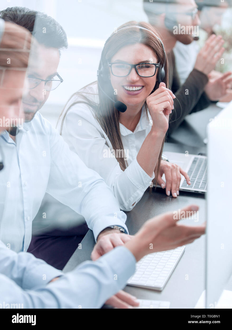 smiling employees of call center talk sitting behind a Desk Stock Photo ...