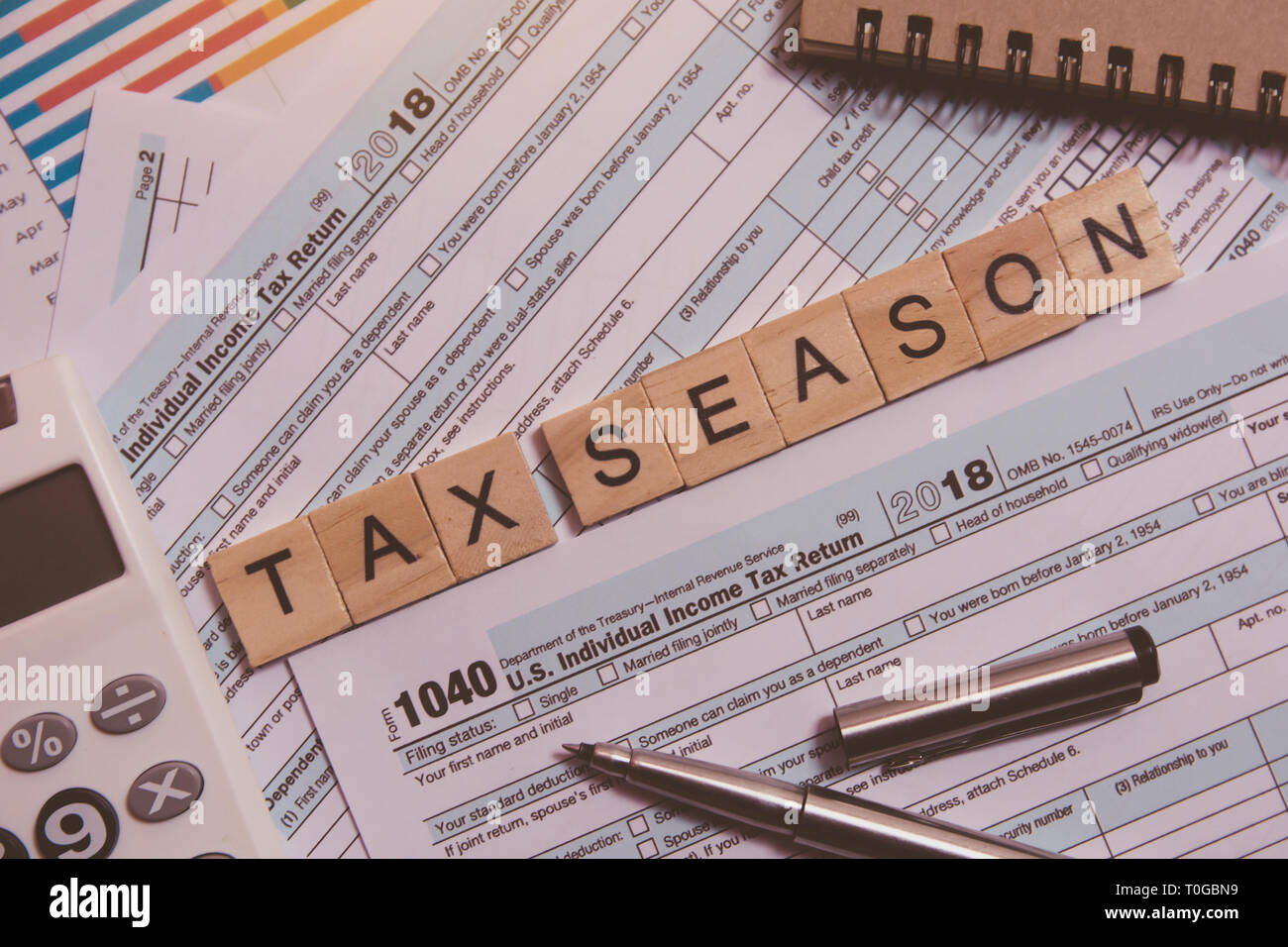 Tax season with wooden alphabet blocks, calculator, pen on 1040 tax ...