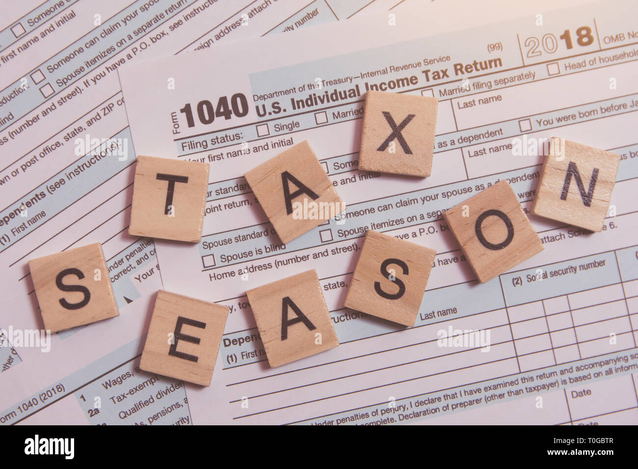Tax season with wooden alphabet blocks on 1040 tax form background ...