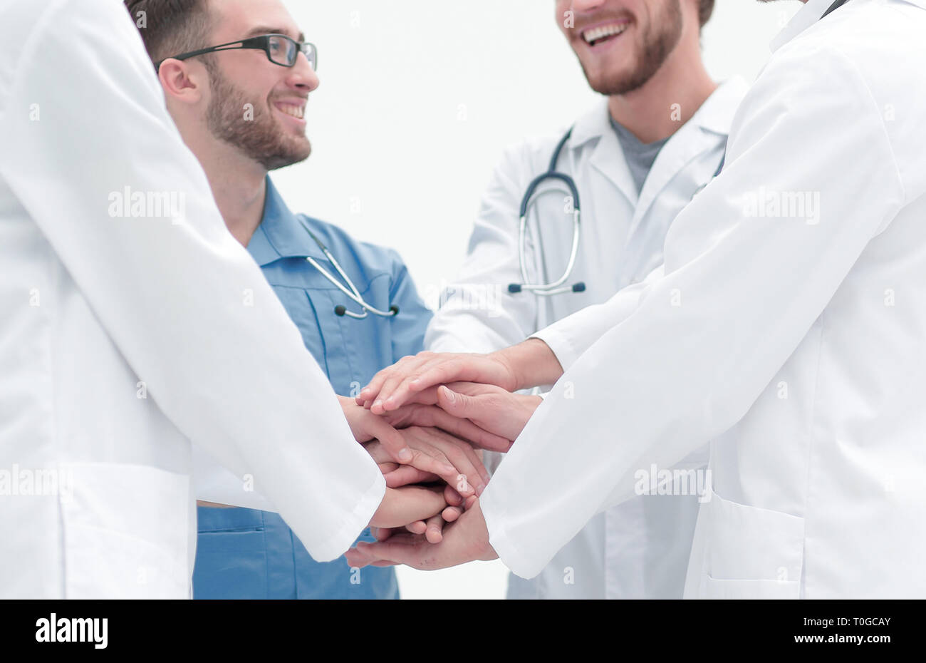 Group doctors joining hands hi-res stock photography and images - Alamy