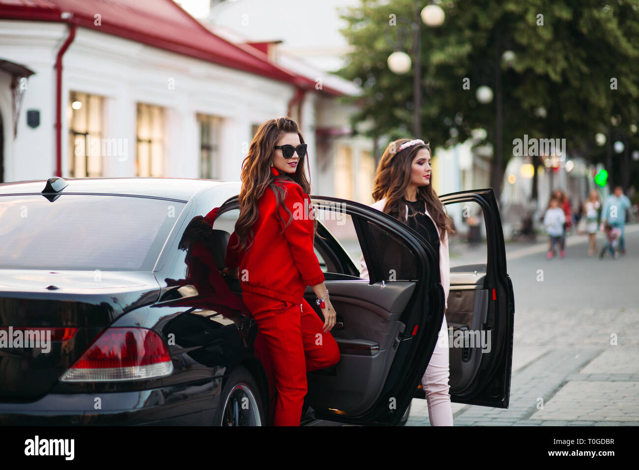 Fashionable ladies going out of the car Stock Photo - Alamy