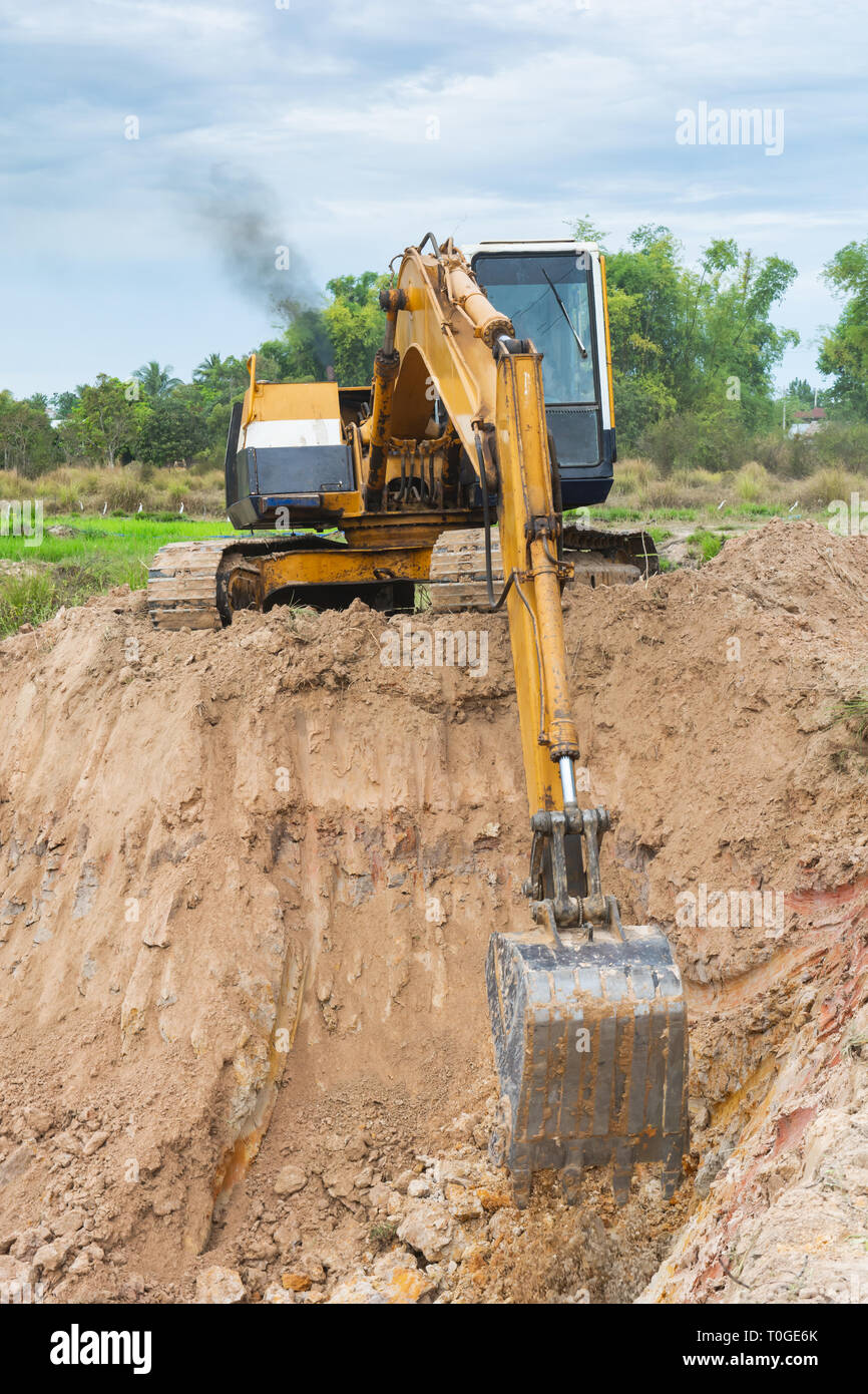 Yellow excavator machine working earth moving works at construction ...