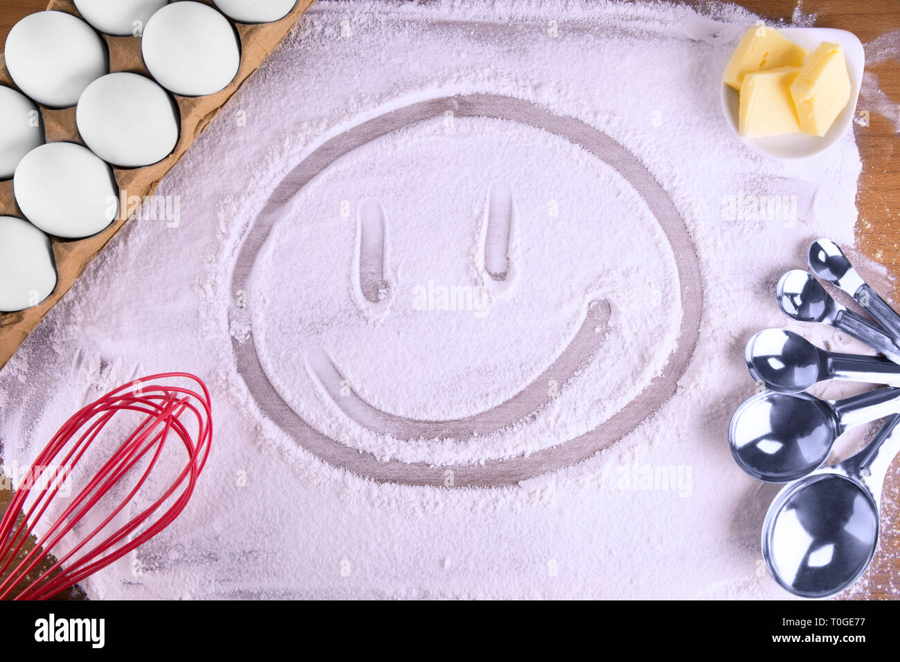 Happy face made with cooking flour on a wooden table. Top view Stock ...
