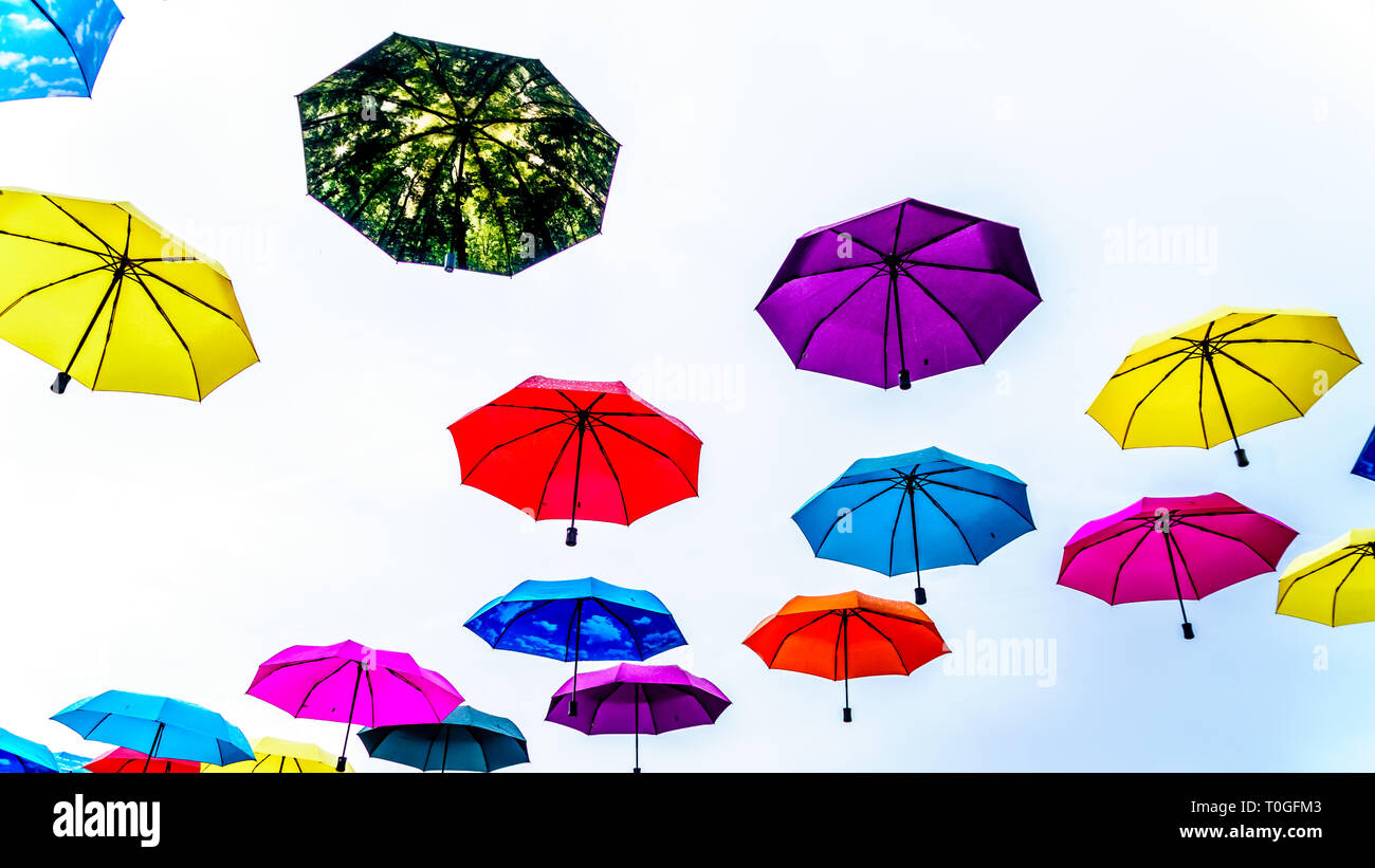 Colorful Umbrellas floating in the air under cloudy sky Stock Photo - Alamy