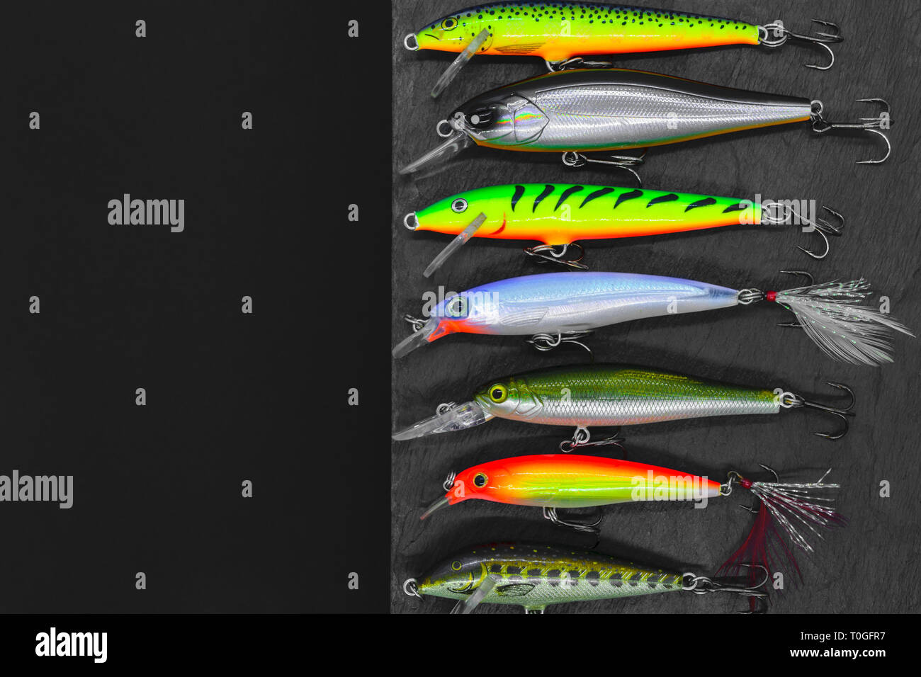 Fishing wobblers lures placed on black stone background with black ...