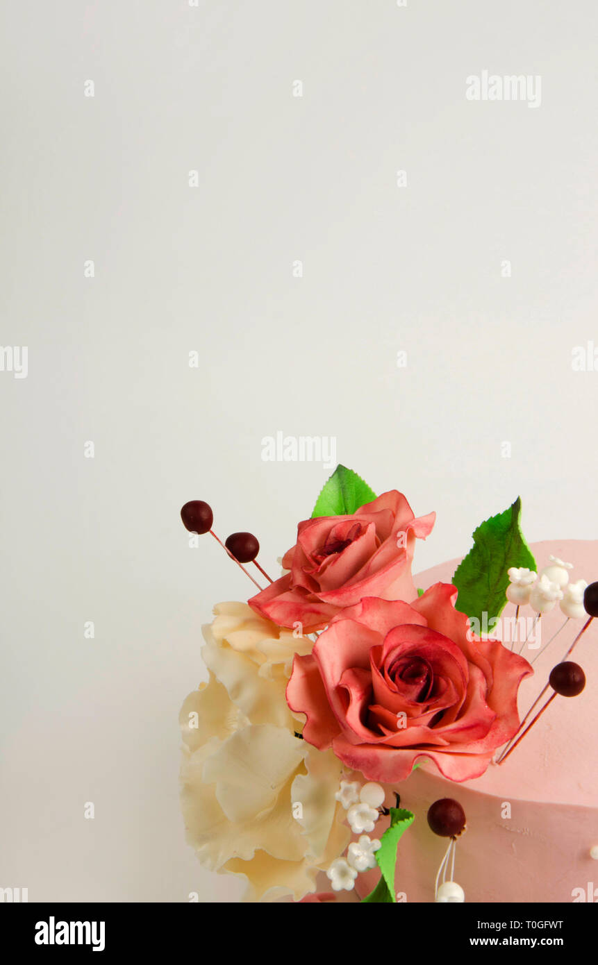 Cake decorated with pink rose flowers and leaves on white background ...