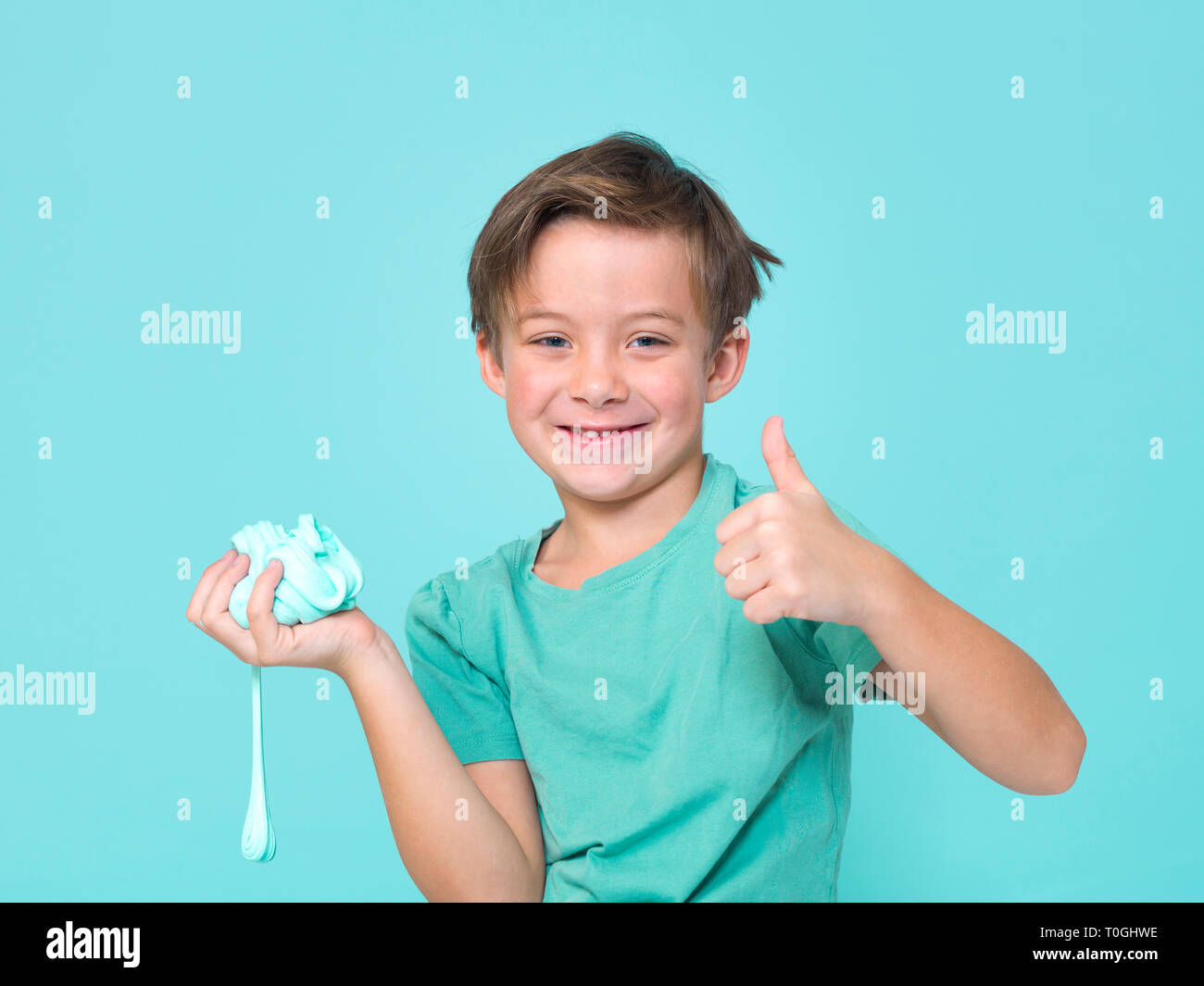 cool, pretty boy plays with homemade slime in front of a blue ...