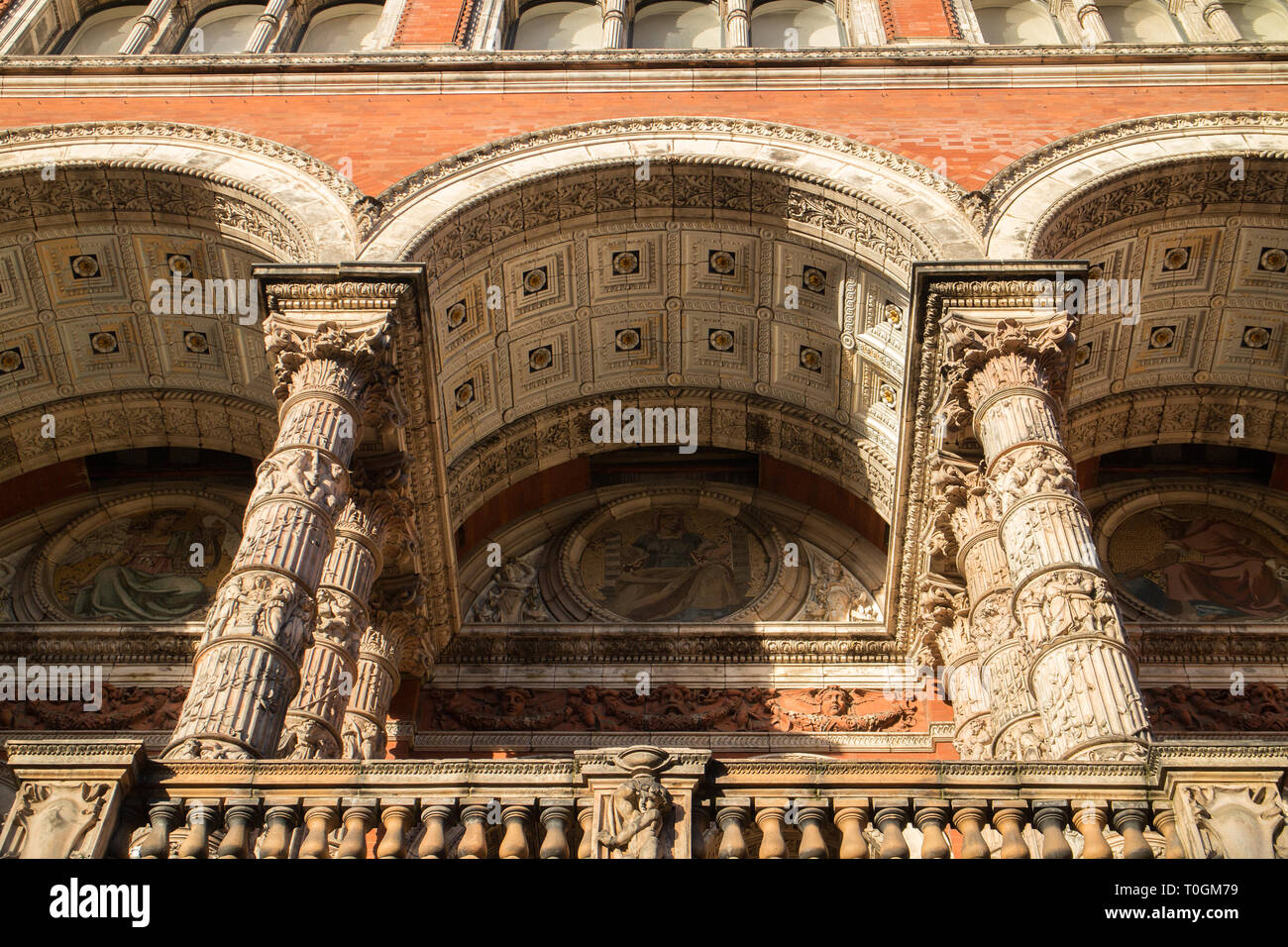 Elaborately decorated arches and columns on upper part of the facade of ...