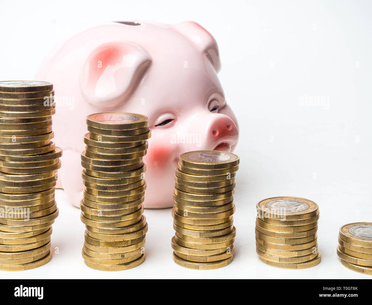 tower of coins isolated on white background with pink toy saving pig ...