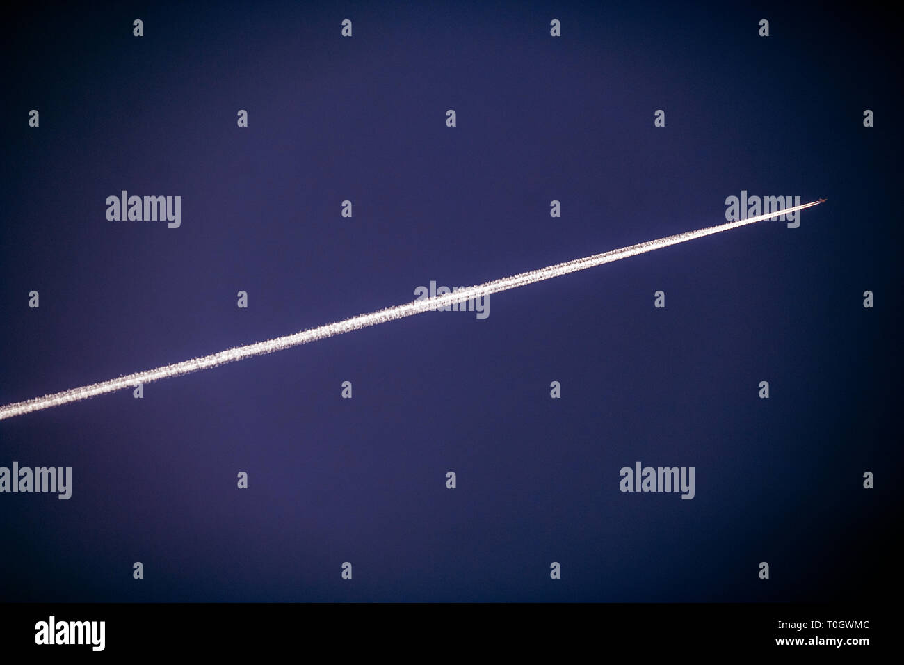 Commercial airline jet contrails across a clear blue sky Stock Photo ...