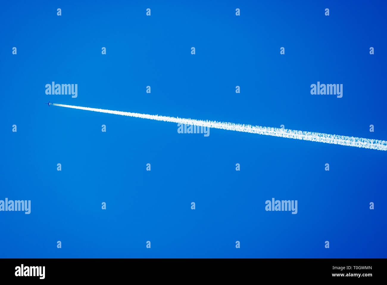 Commercial airline jet contrails across a clear blue sky Stock Photo ...