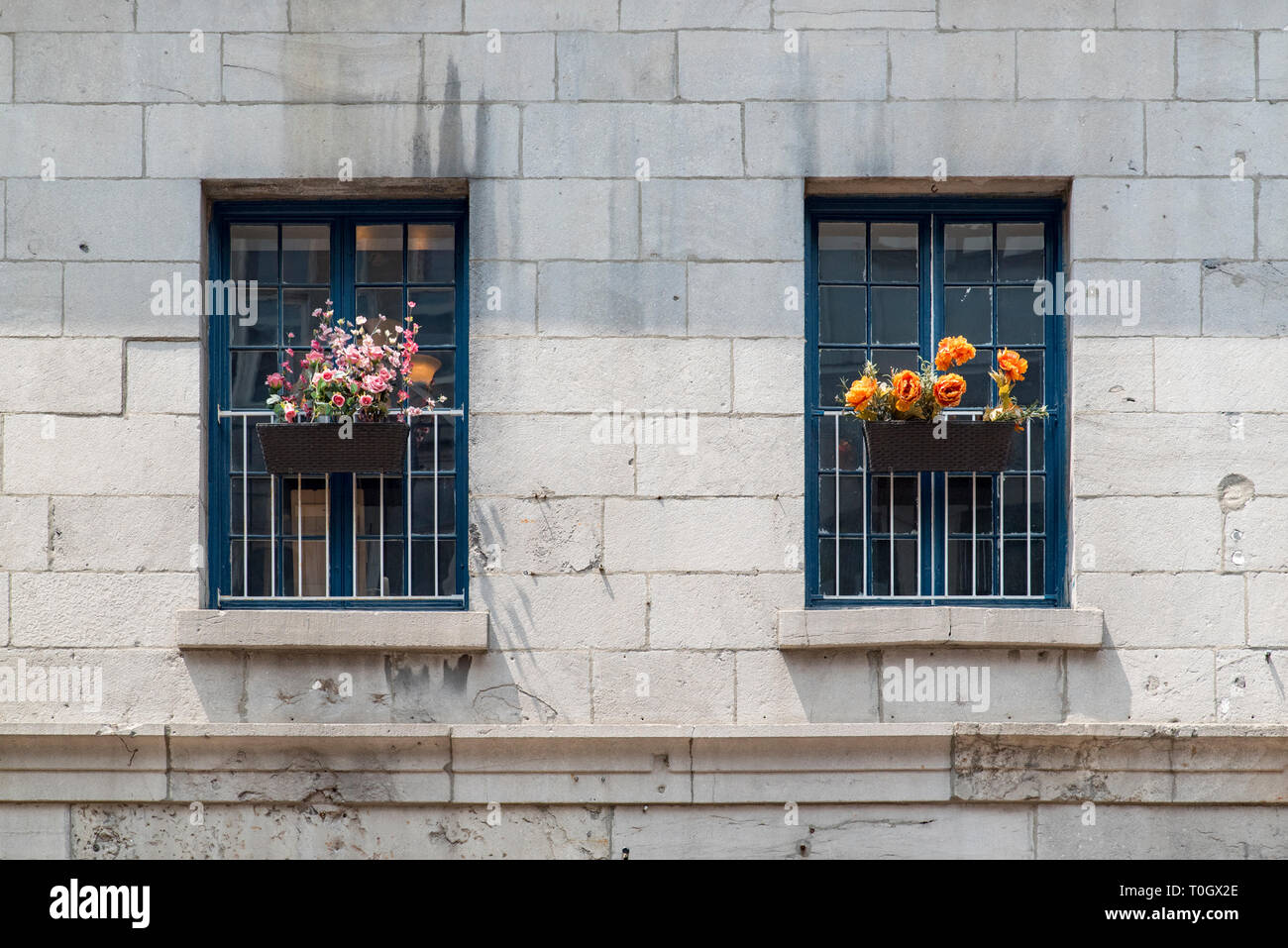 Old Montreal, Quebec, Canada. Two old windows with brown wicker flower ...