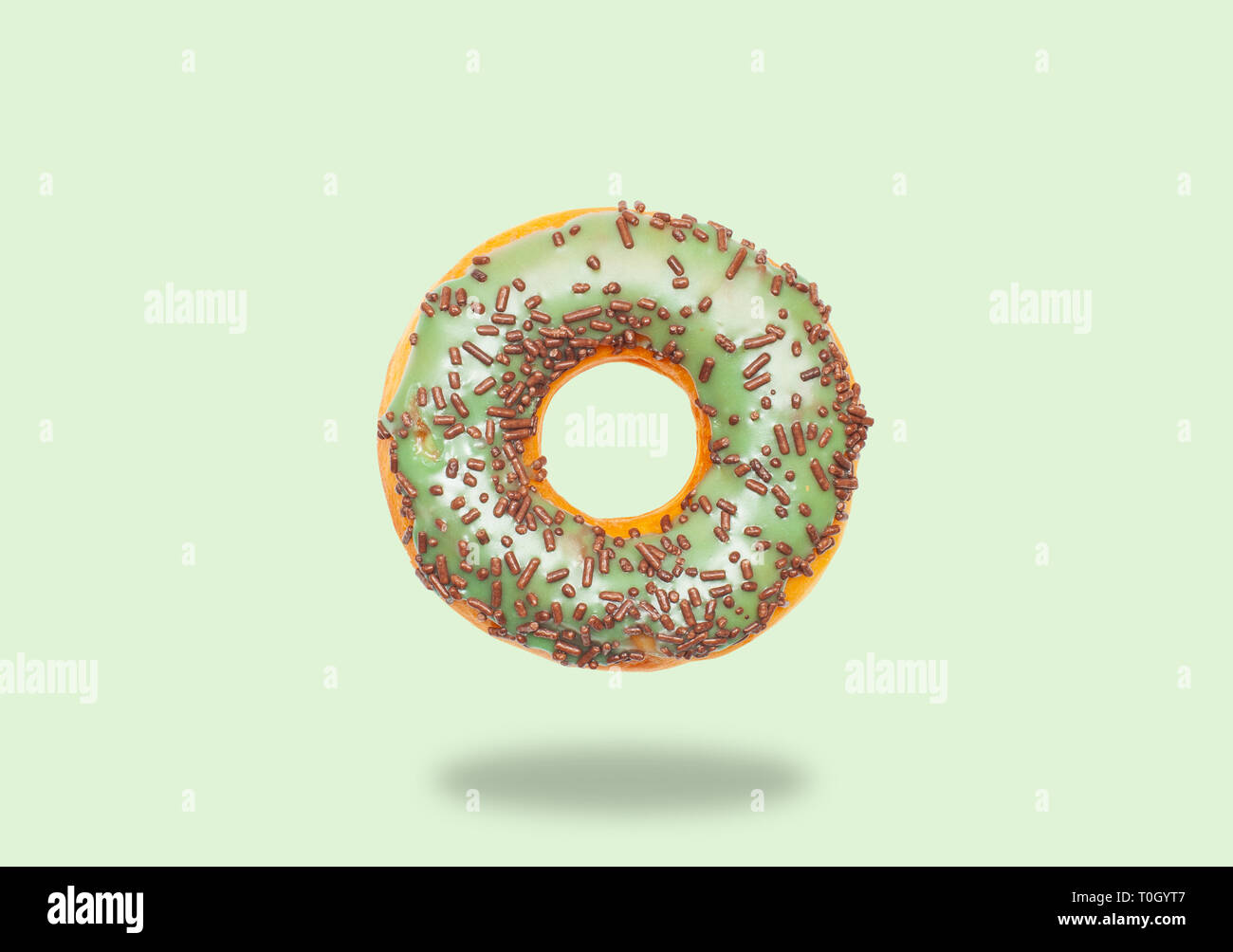 Green donut with icing on pastel green background Stock Photo - Alamy