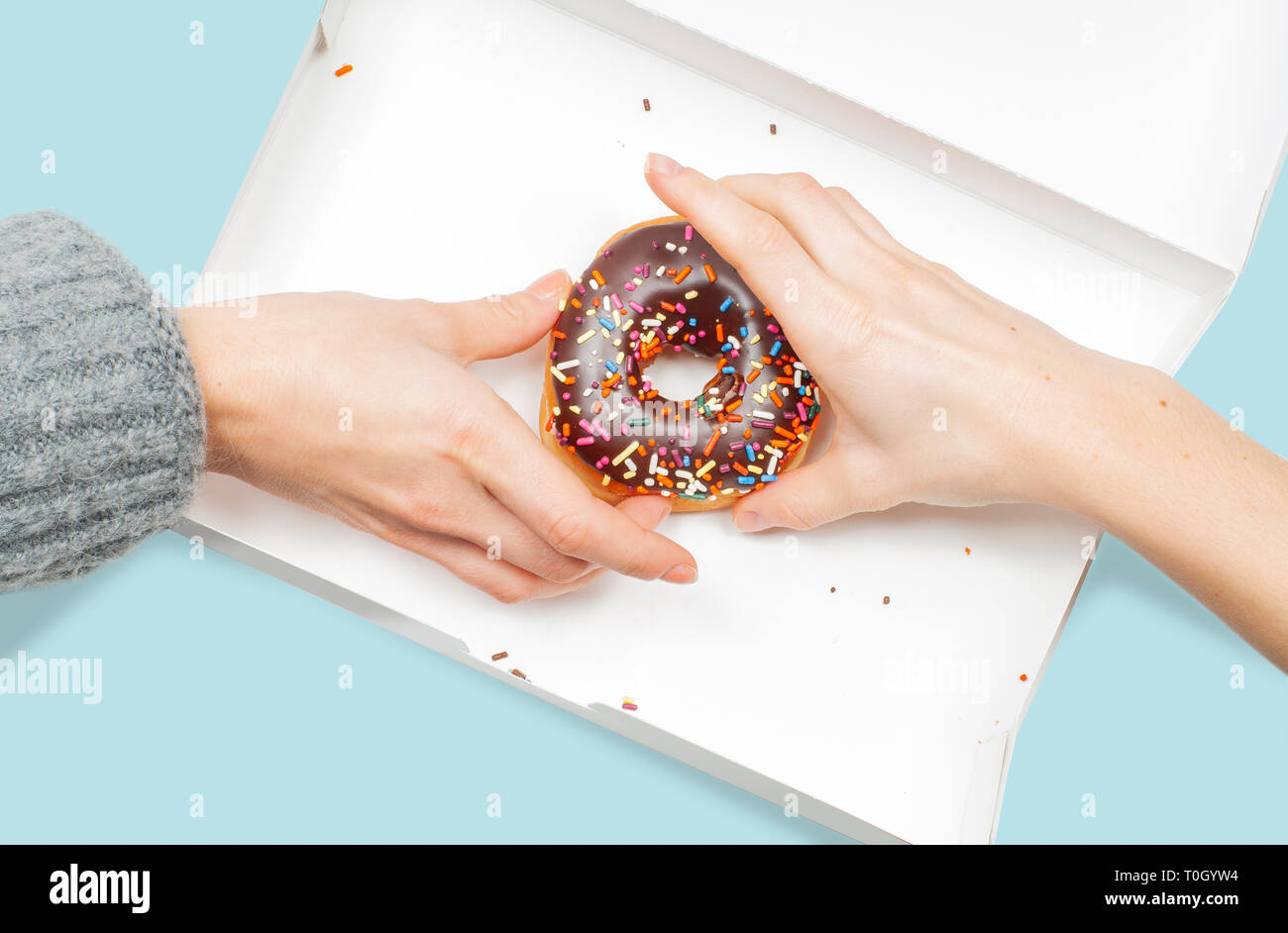Female hands is taking colorful donuts. Hands is grabbing last donuts ...