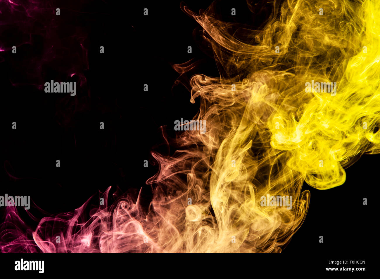 Colorful pink and yellow smoke on a black isolated background ...