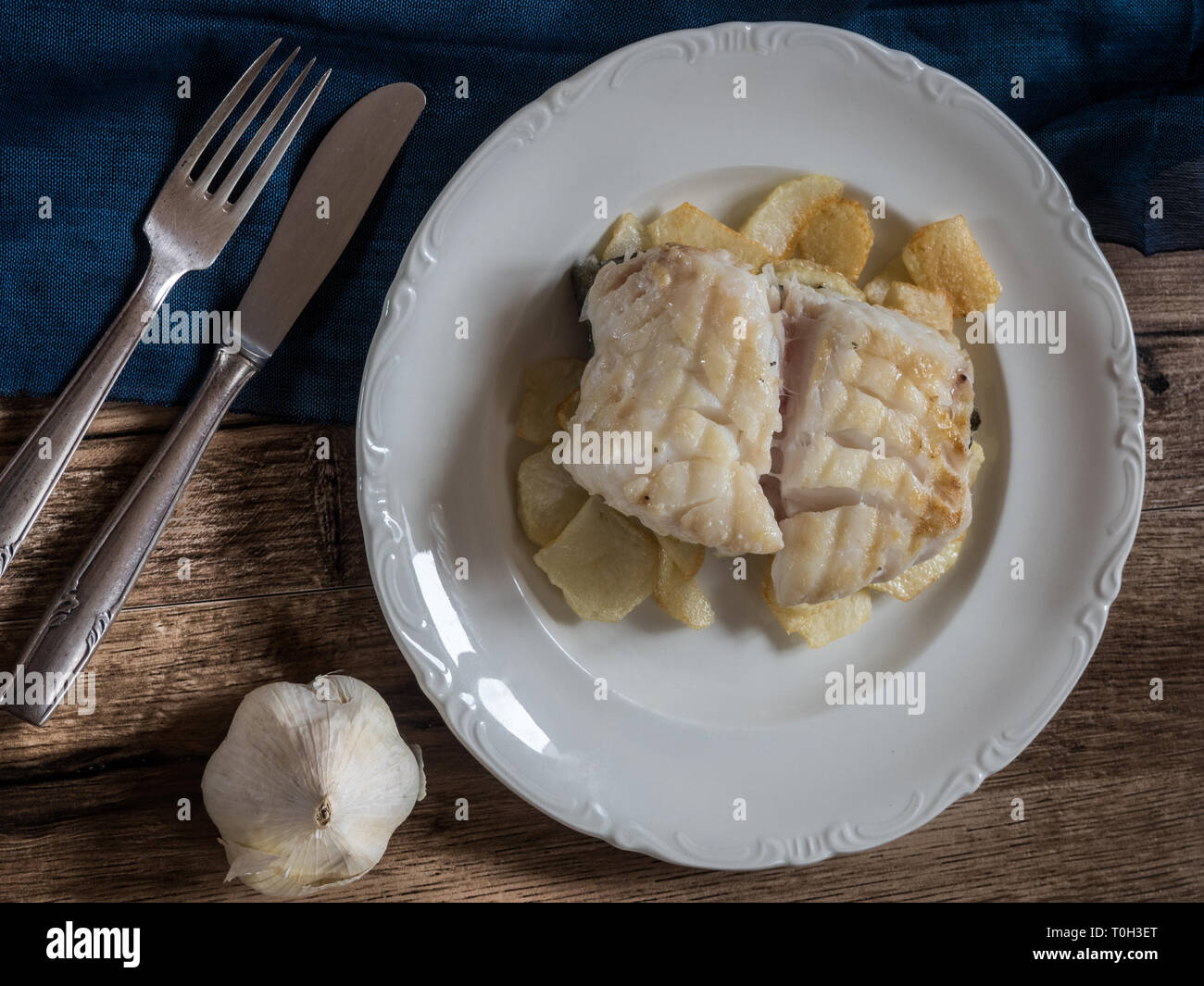 Grilled cod with potatoes on a plate Stock Photo - Alamy