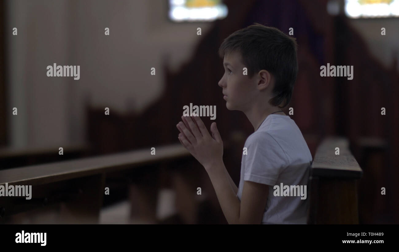serious boy praying in the Church alone, have fun Stock Photo - Alamy