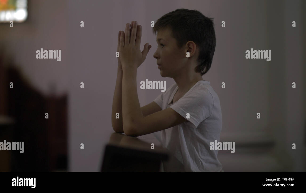 serious boy praying in the Church alone, have fun Stock Photo - Alamy