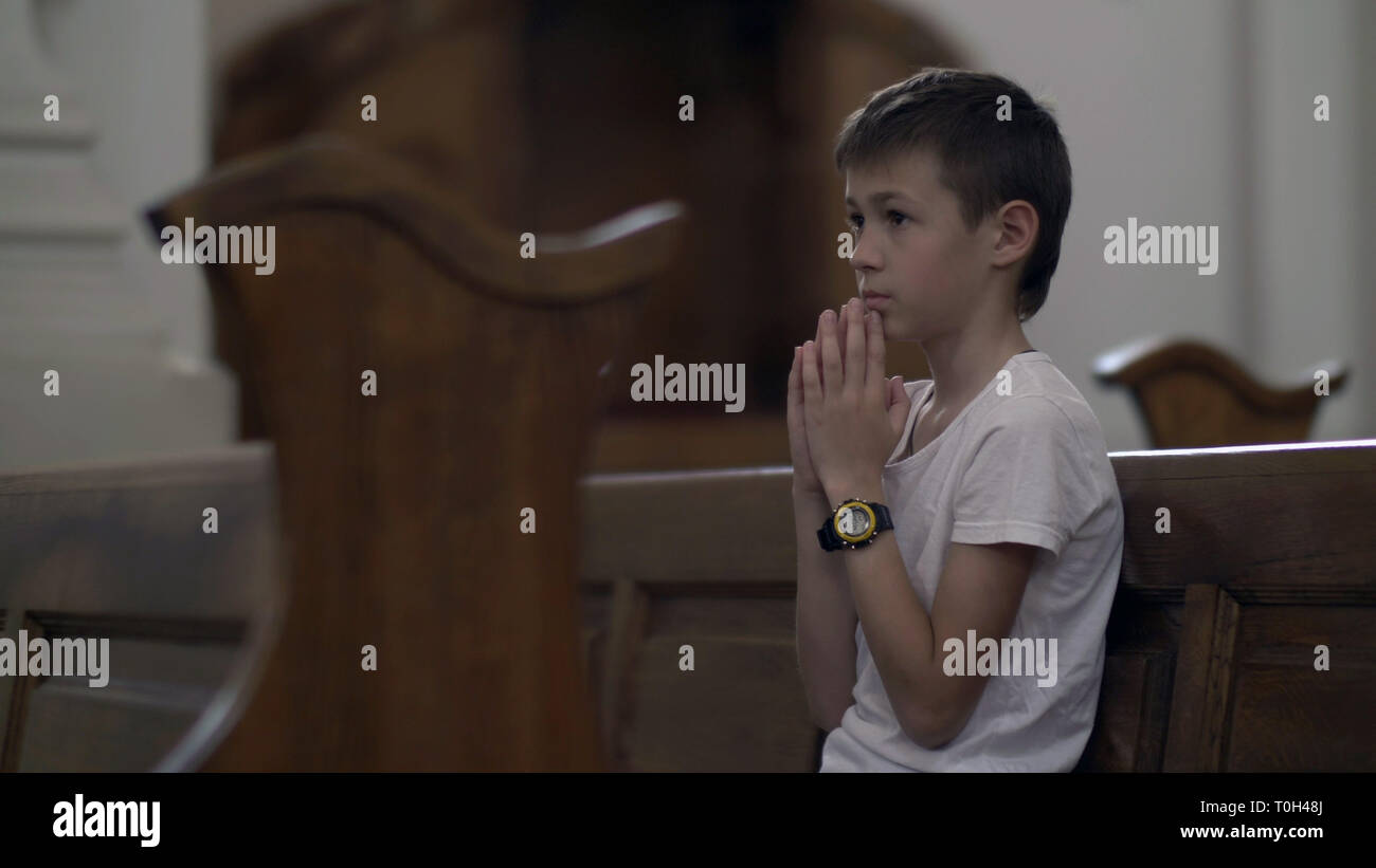 serious boy praying in the Church alone, have fun Stock Photo - Alamy
