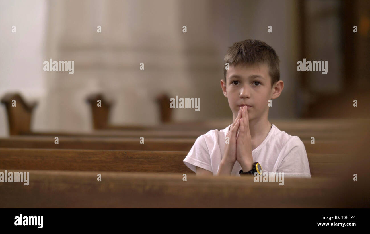 serious boy praying in the Church alone, have fun Stock Photo - Alamy