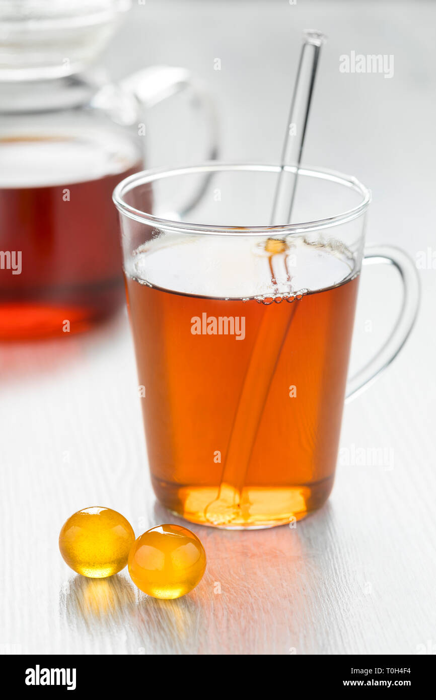Glass of hot tea with yellow honey pearls Stock Photo - Alamy