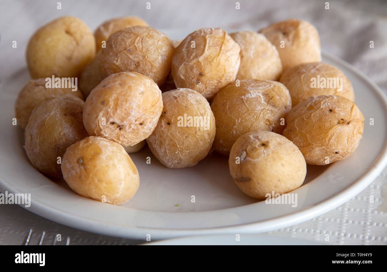 Portion of Canarian wrinkly potatoes on a white plate Stock Photo - Alamy
