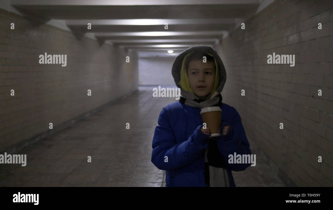 boy walks through the tunnel in the winter and drinks coffee Stock ...
