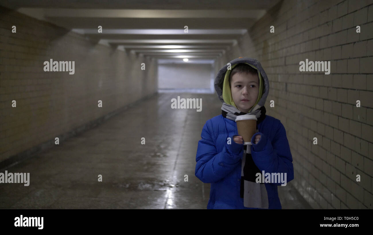 boy walks through the tunnel in the winter and drinks coffee Stock ...